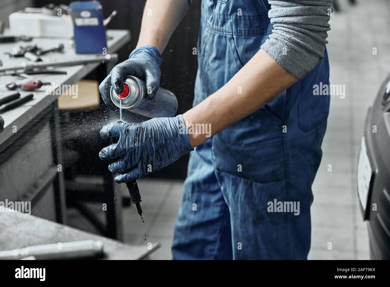 Close up of auto mechanic working process wearing rubber protective ...
