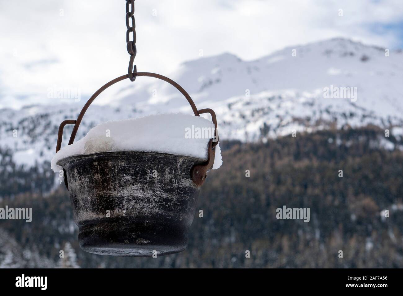Old metal pot full of snow in alpine panorama background Stock Photo ...
