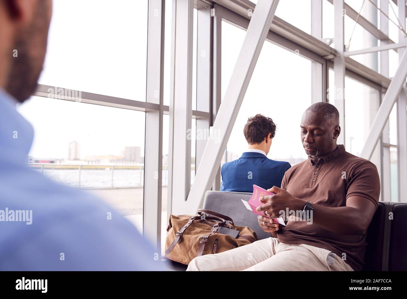 Male Passenger In Airport Departure Lounge Checking Travel Documents ... Male Passenger In Airport Departure Lounge Checking Travel Documents ...