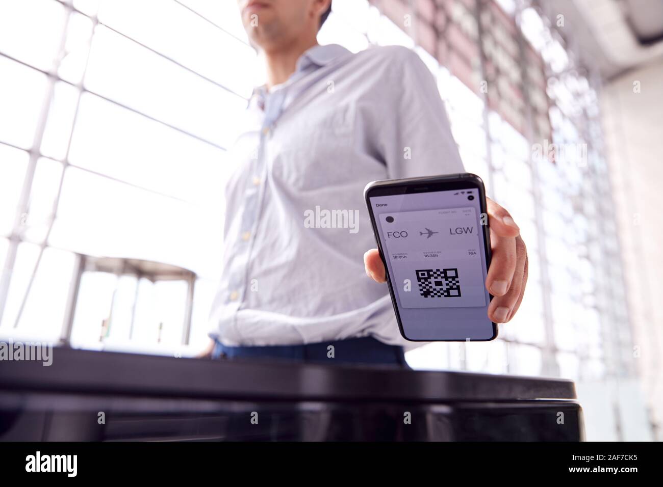 Male Passenger In Airport Departure Lounge Scanning Digital Boarding ...