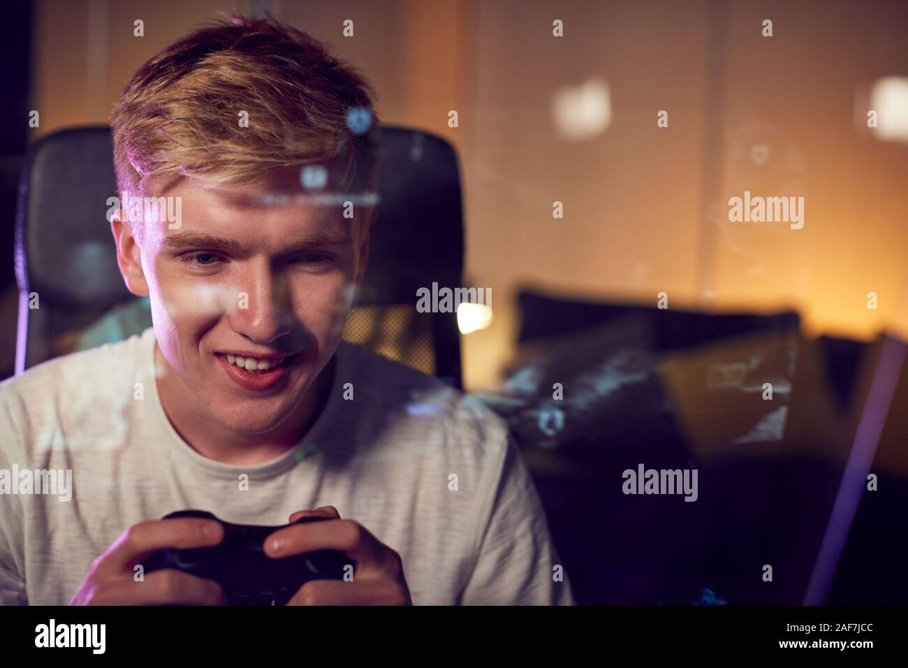 Teenage Boy With Game Pad Sitting In Chair and Gaming At Home With ...
