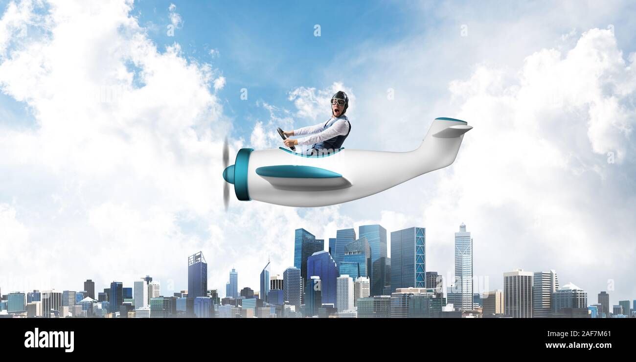 Businessman in aviator hat and goggles driving propeller plane above ...