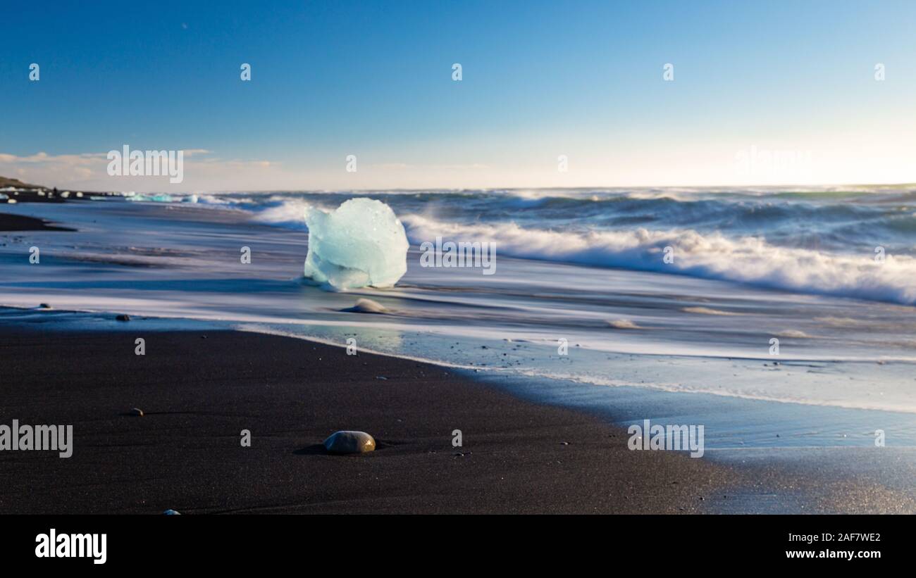Iceberg melting on black volcano beach of Jökulsárlón glacier lagoon ...