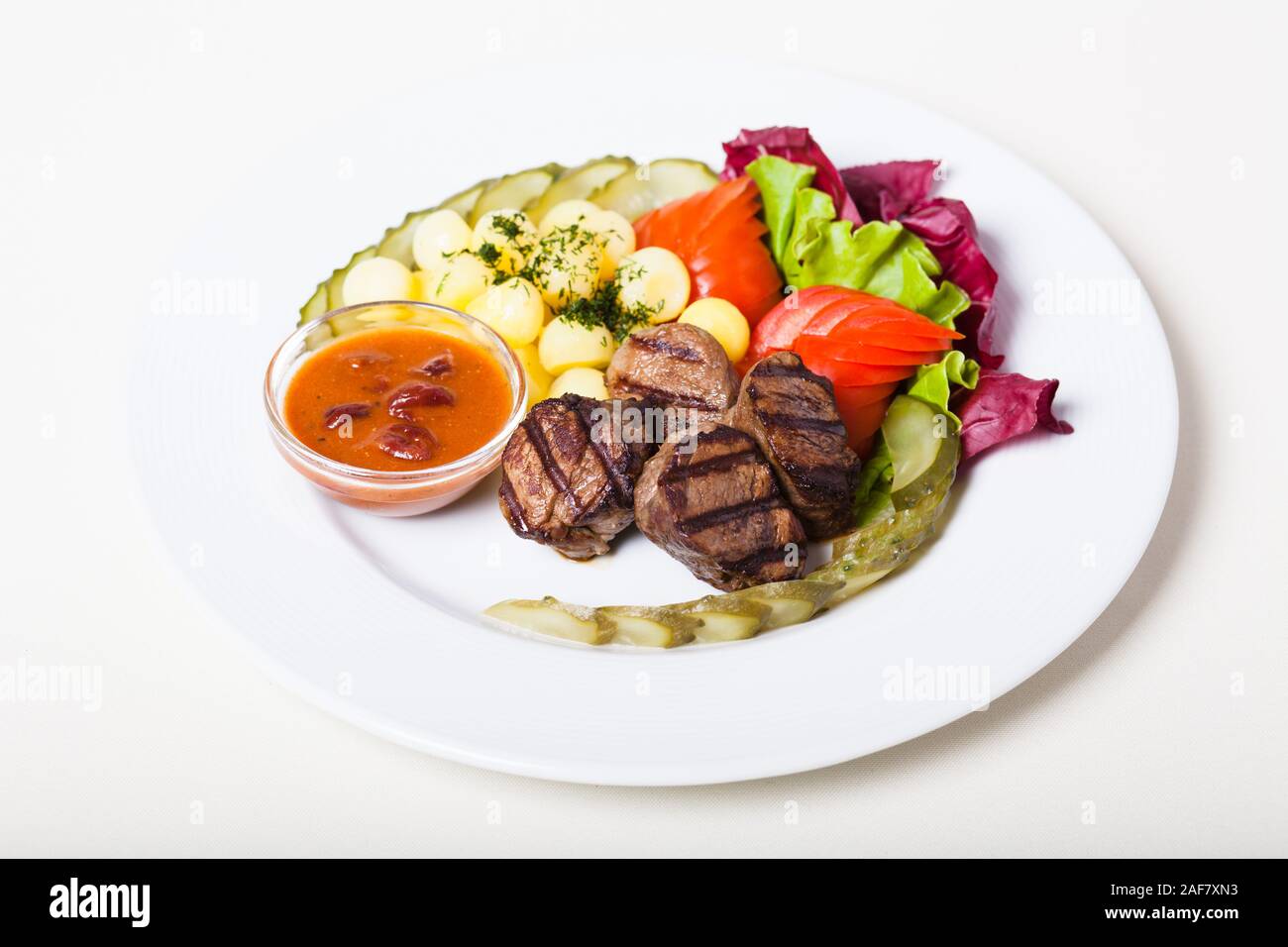 Grilled meat with vegetable garnish Stock Photo - Alamy