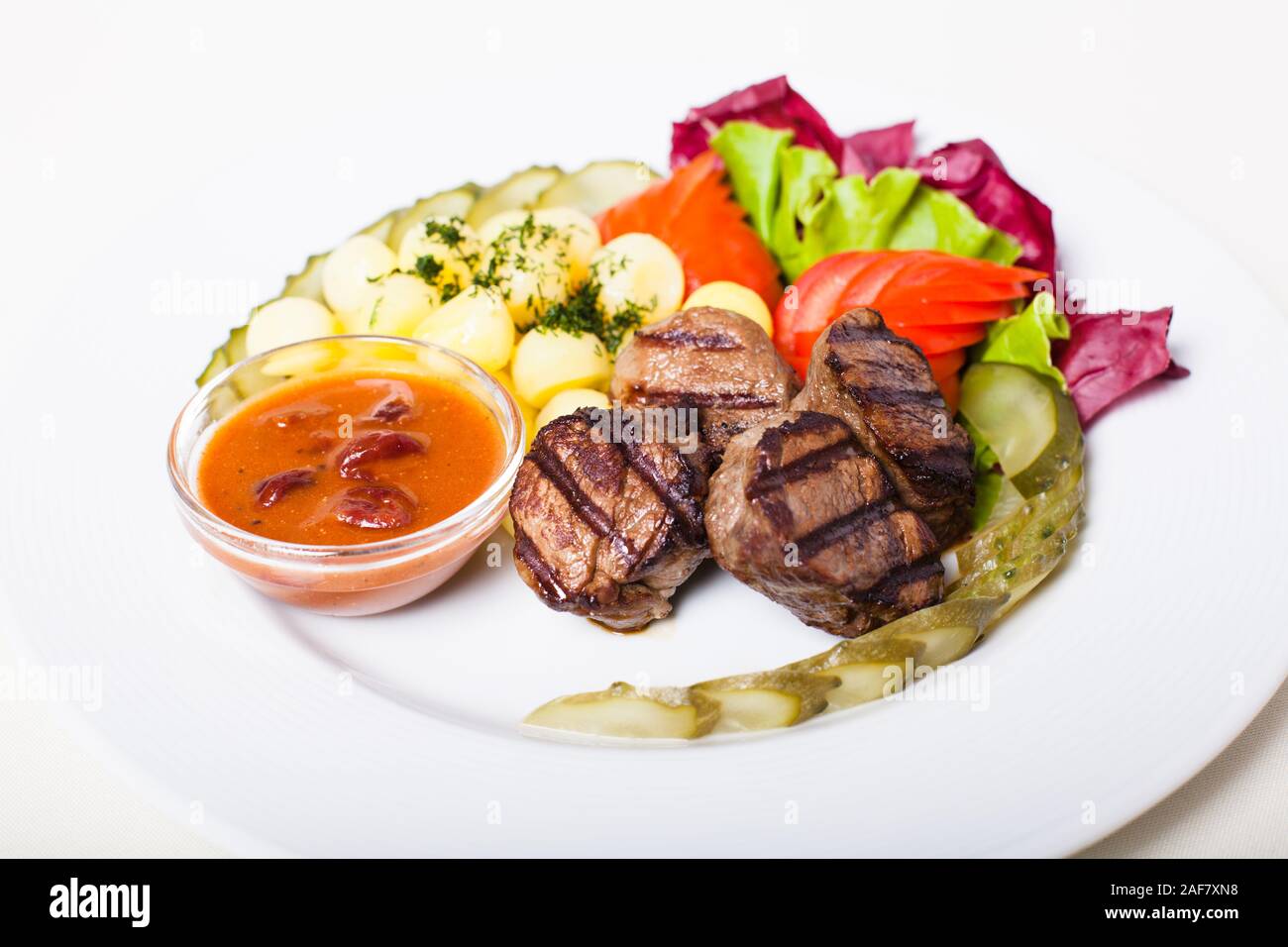 Grilled meat with vegetable garnish Stock Photo - Alamy