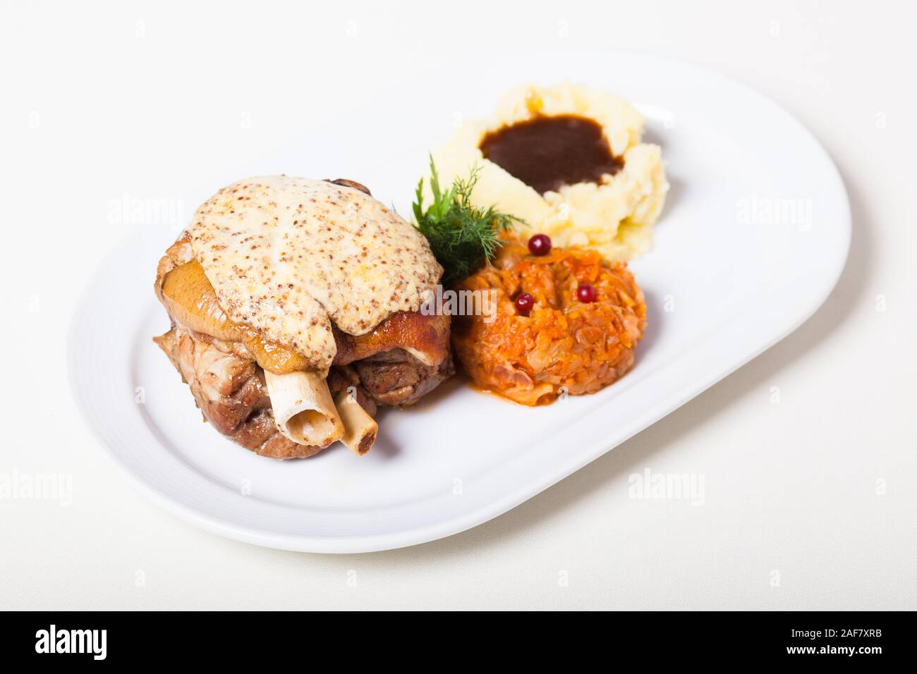 Baked pork knuckle with mustard sauce and mashed potato and stewed ...