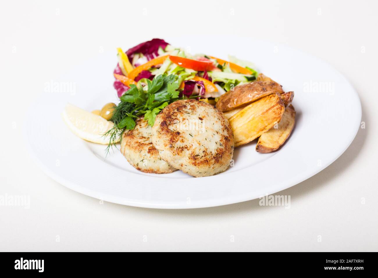 Fried fish cutlets with raw vegetable salad and grilled potato Stock ...