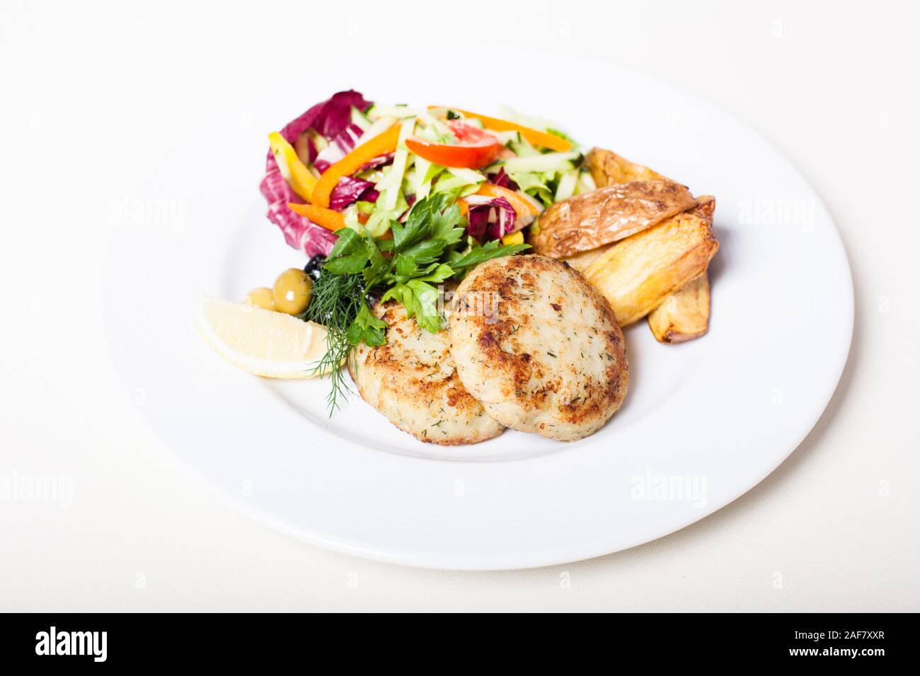 Fried fish cutlets with raw vegetable salad and grilled potato Stock ...