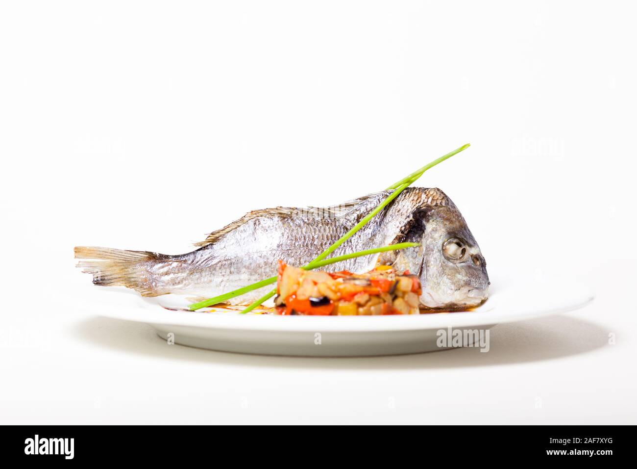 Baked dorado fish with vegetables Stock Photo - Alamy