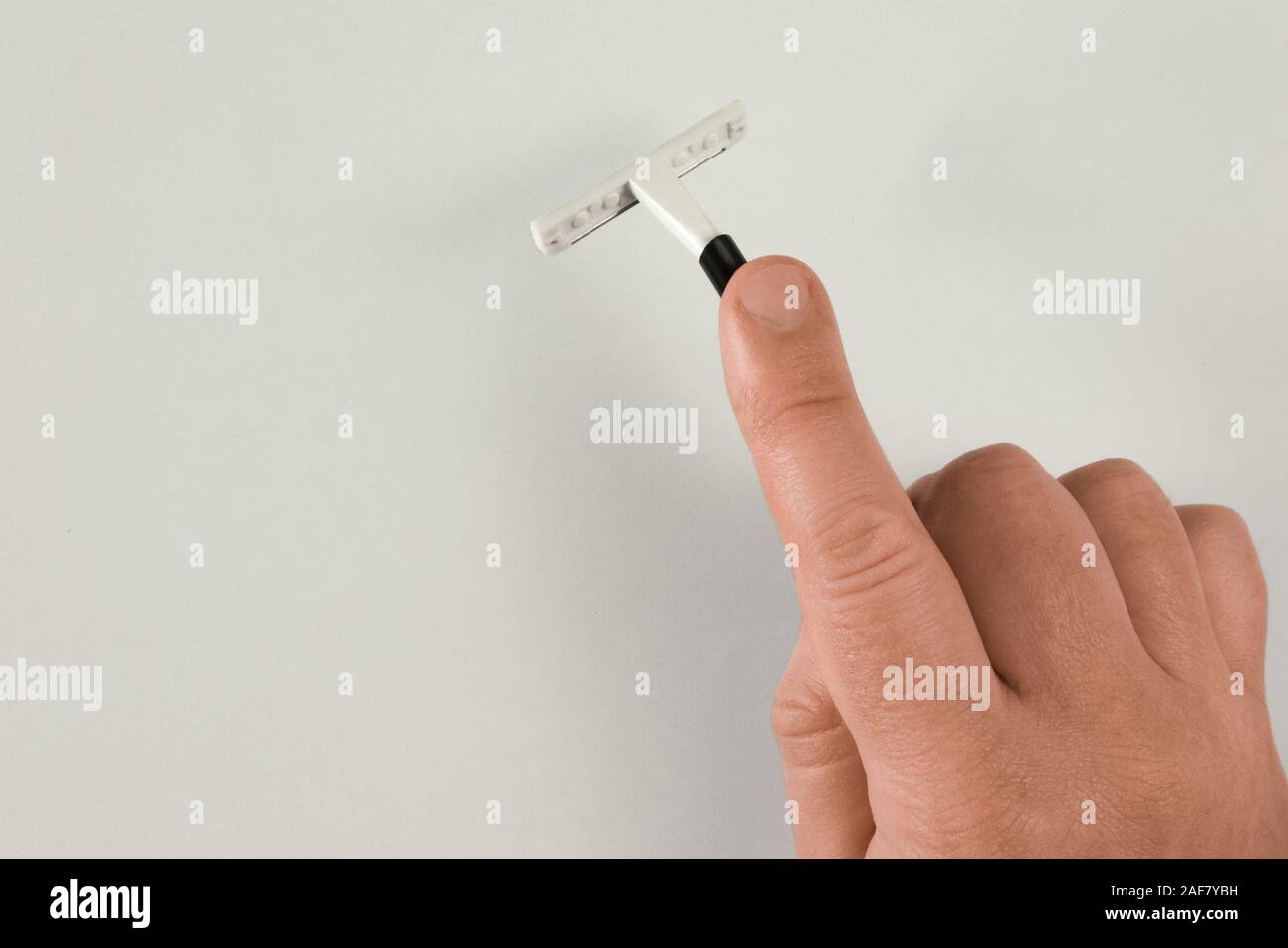 Man hand holds shaving stick. Mock-up on light background with shadow ...