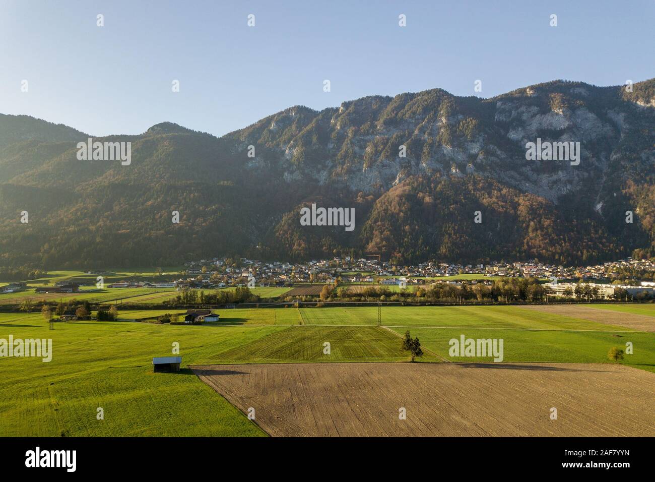Aerial view of green meadows with villages and forest in austrian Alps ...