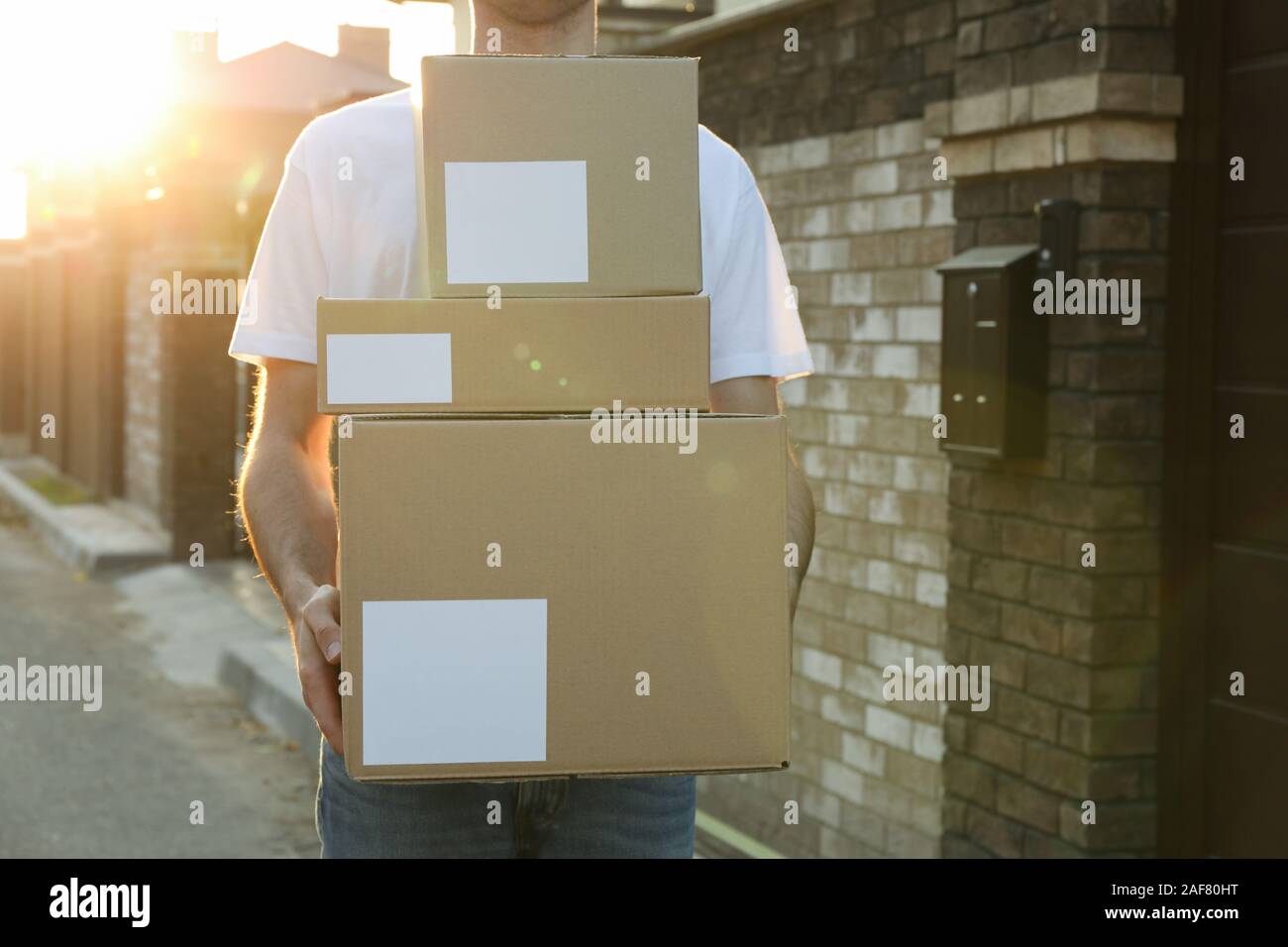 Delivery man hold blank boxes outdoor, space for text Stock Photo - Alamy