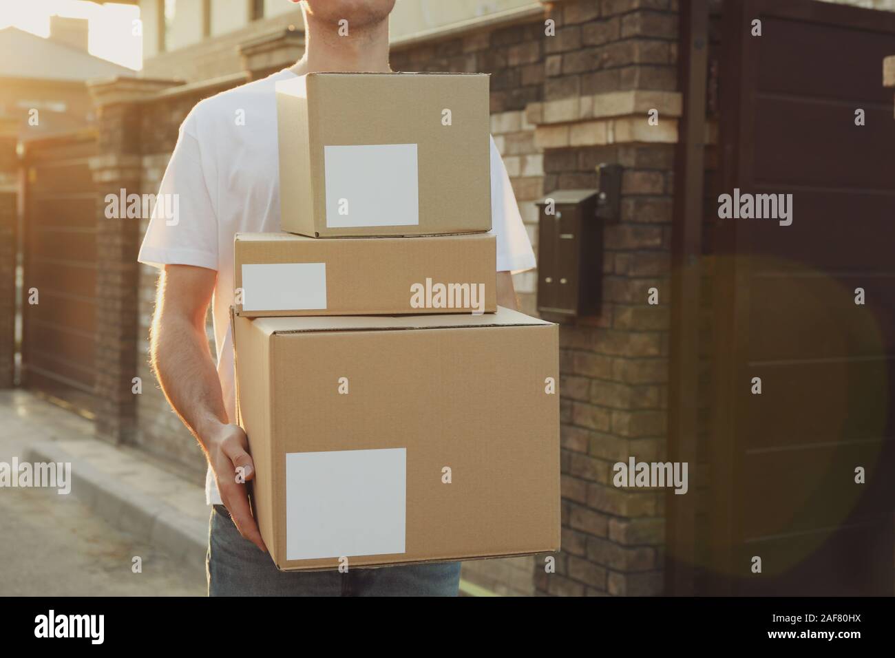 Delivery man hold blank boxes outdoor, space for text Stock Photo - Alamy