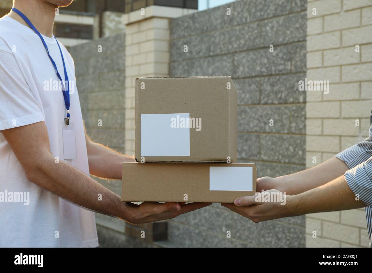 Man receiving boxes from delivery man outdoor, blank space Stock Photo ...