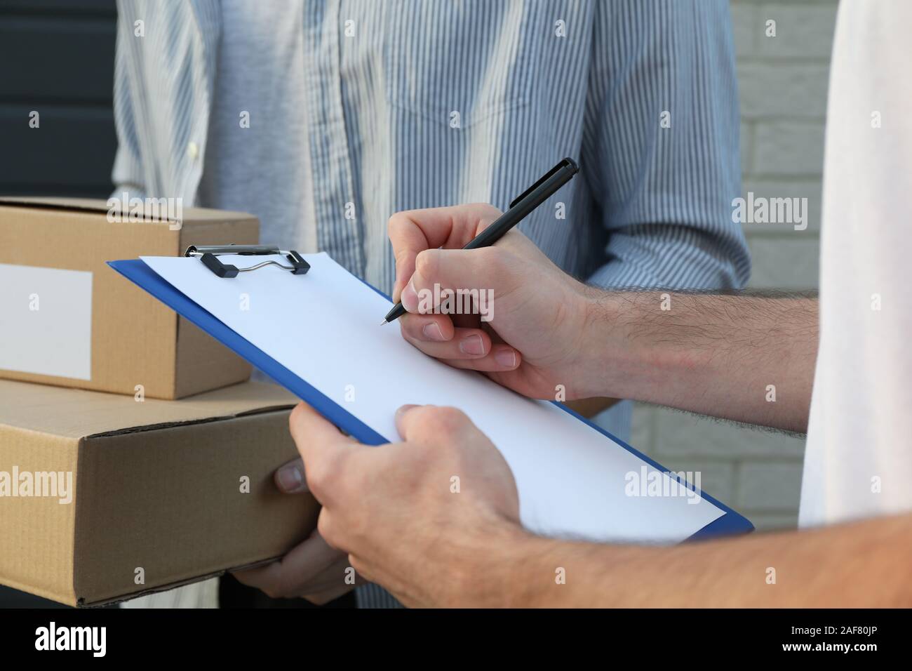 Man with boxes and delivery man outdoor, blank space Stock Photo - Alamy