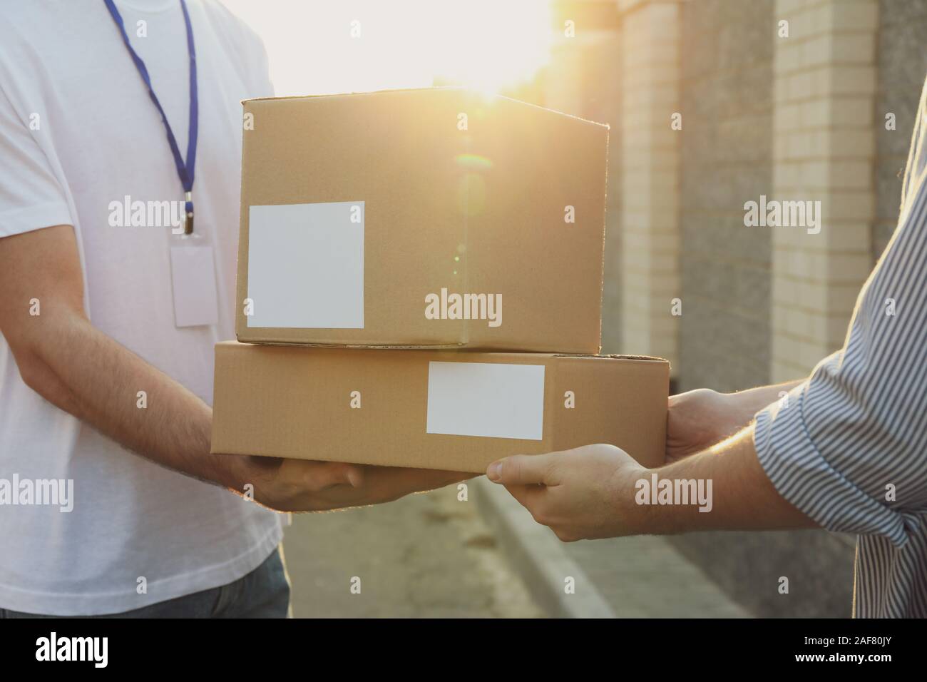 Man receiving boxes from delivery man outdoor, blank space Stock Photo ...