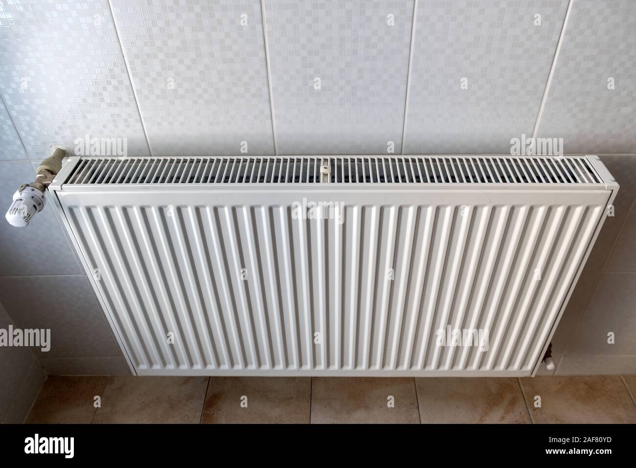 White metal heating radiator mounted on a wall in room interior Stock ...