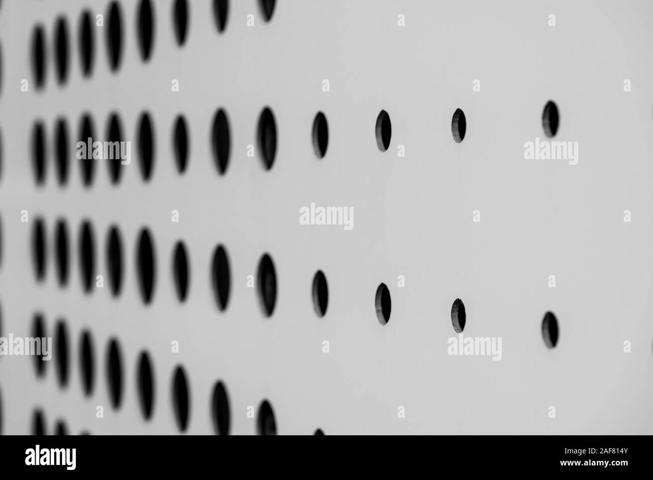 White wall with drilled holes Stock Photo - Alamy
