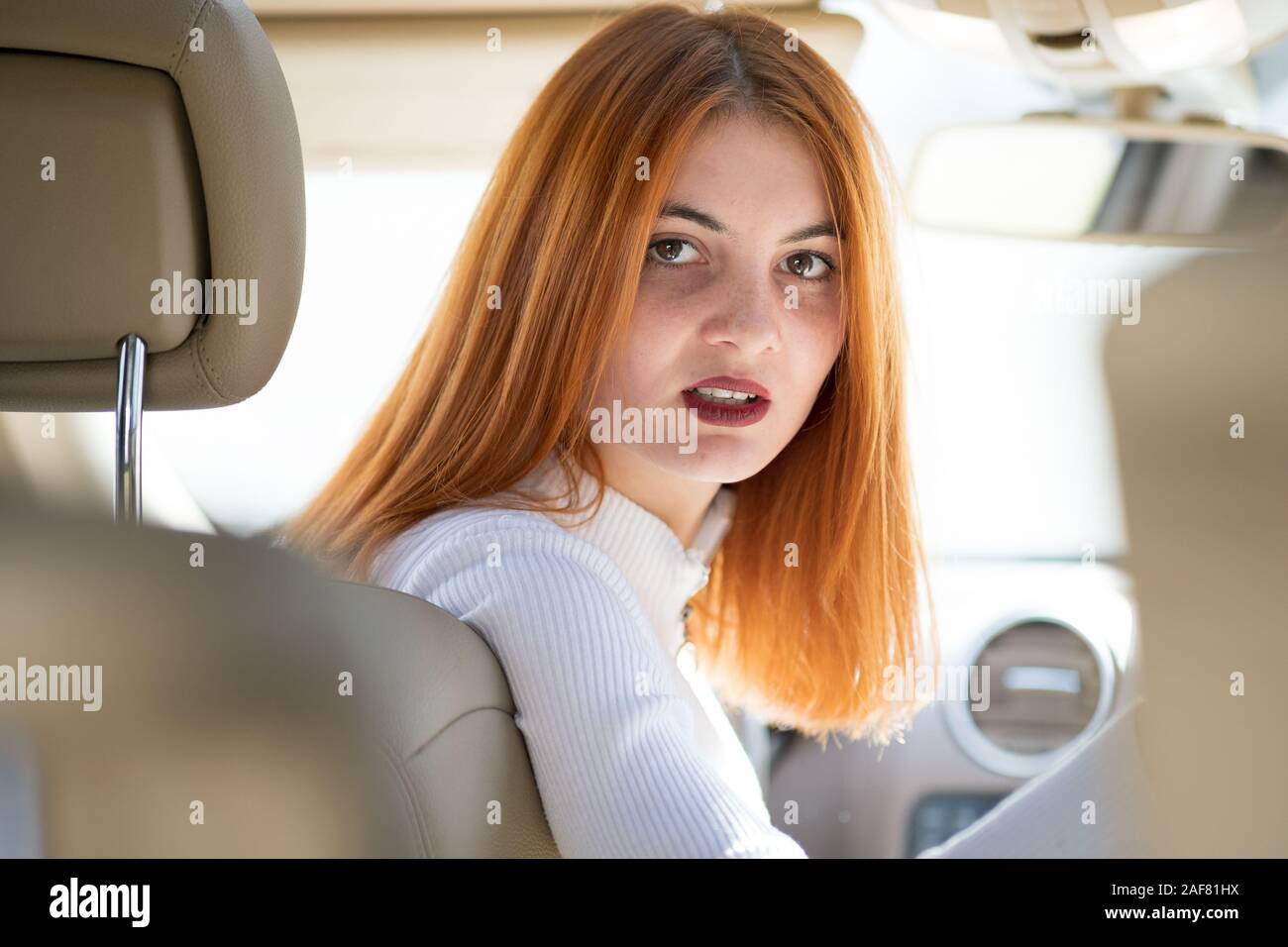 Young redhead woman driver driving a car backwards Stock Photo - Alamy