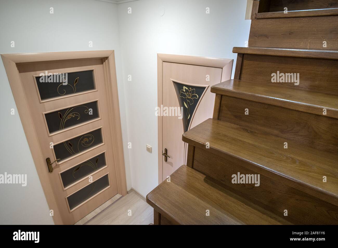 Interior of a house or appartment hallway with oak wooden stairs and ...