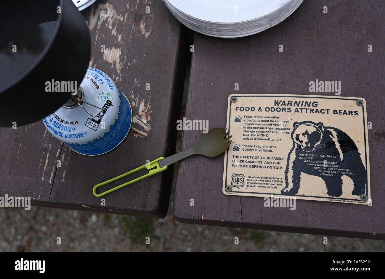 A bear warning sign on a picnic table to store food properly at the ...
