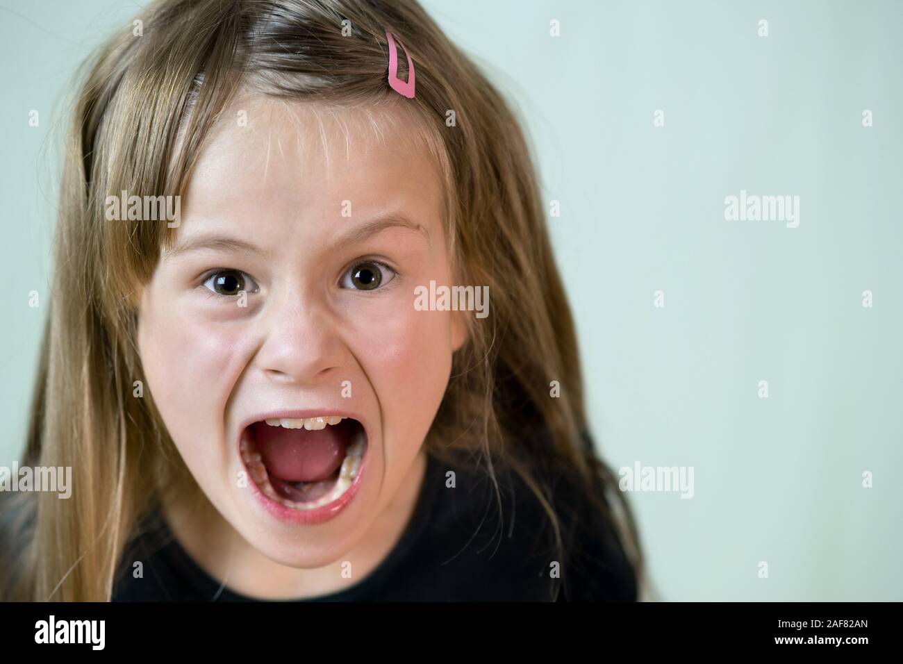 Close up portrait of angry shouting child girl looking aggressively in ...
