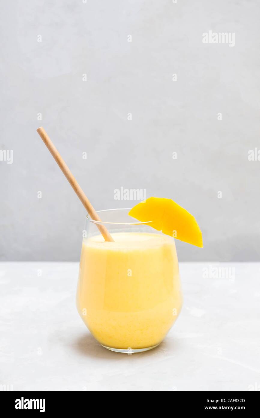 Mango Lassi in a glass cup on neutral grey background with copy space ...