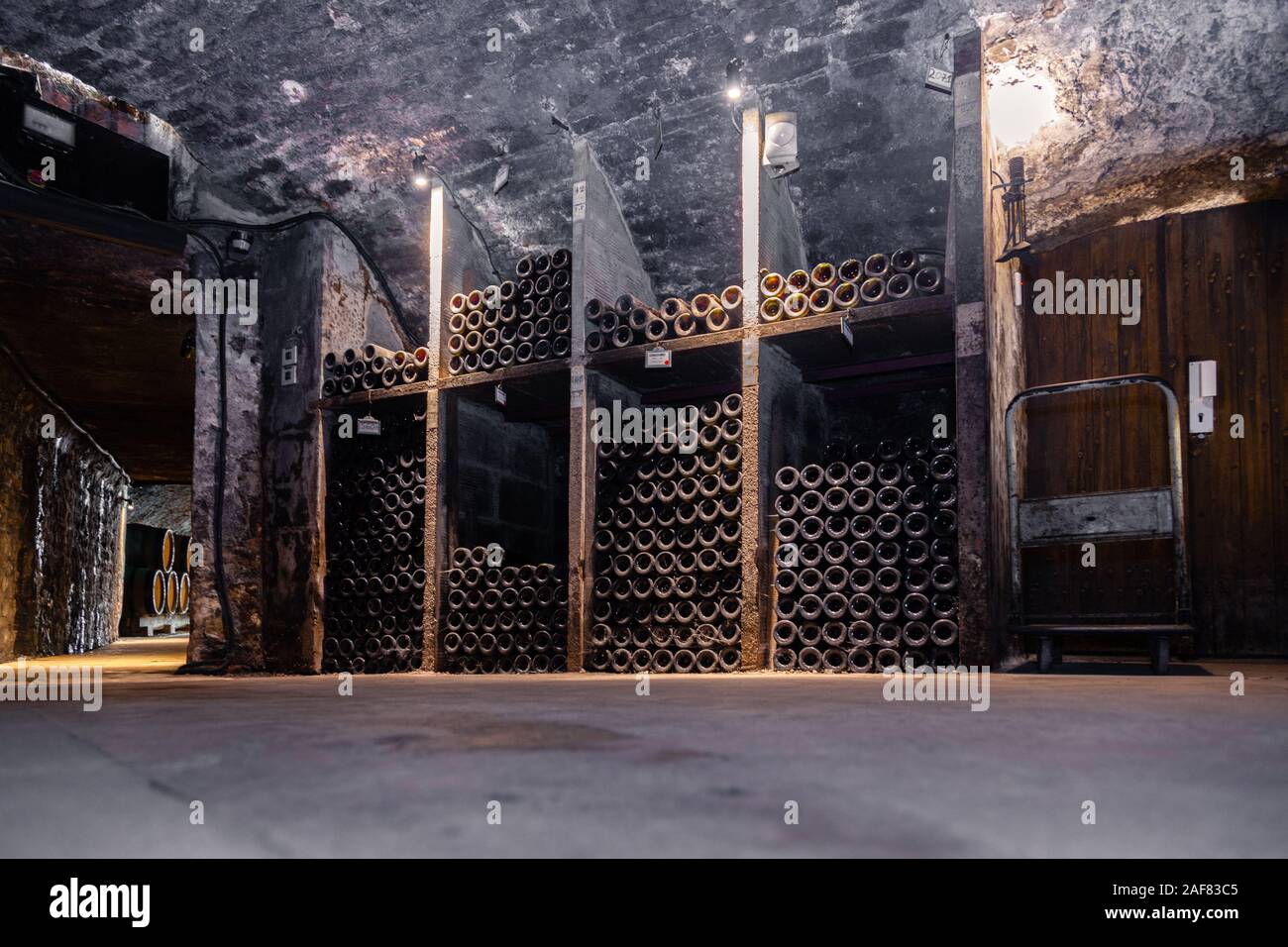 Ancient wine bottles resting, aging, dusting in underground cellar in ...