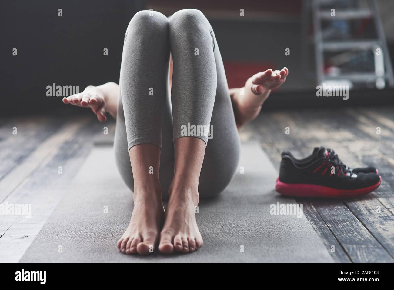 Trying her best. Girl with slender body works on the abs when lying on ...