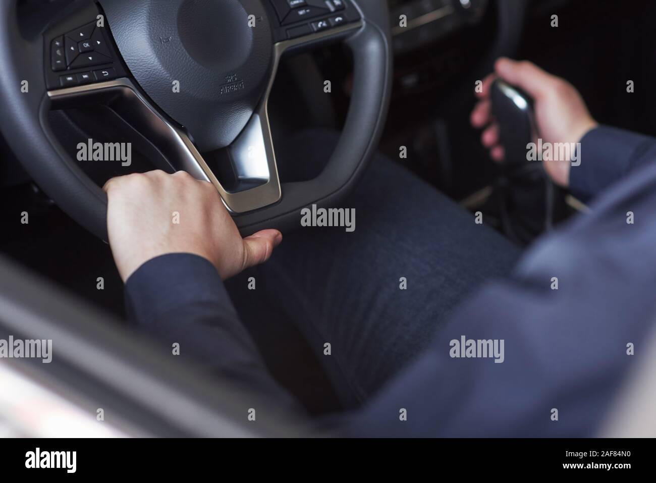 Gear shifting. Man in official clothes trying his new car in automobile ...