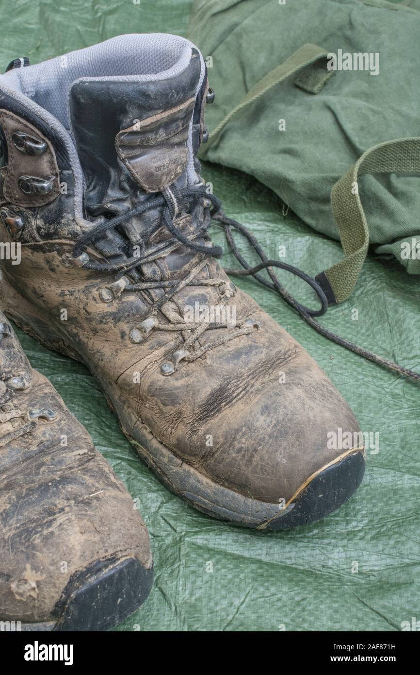 Close shot of muddy bootlaces and eyelets on pair of tired old walking ...