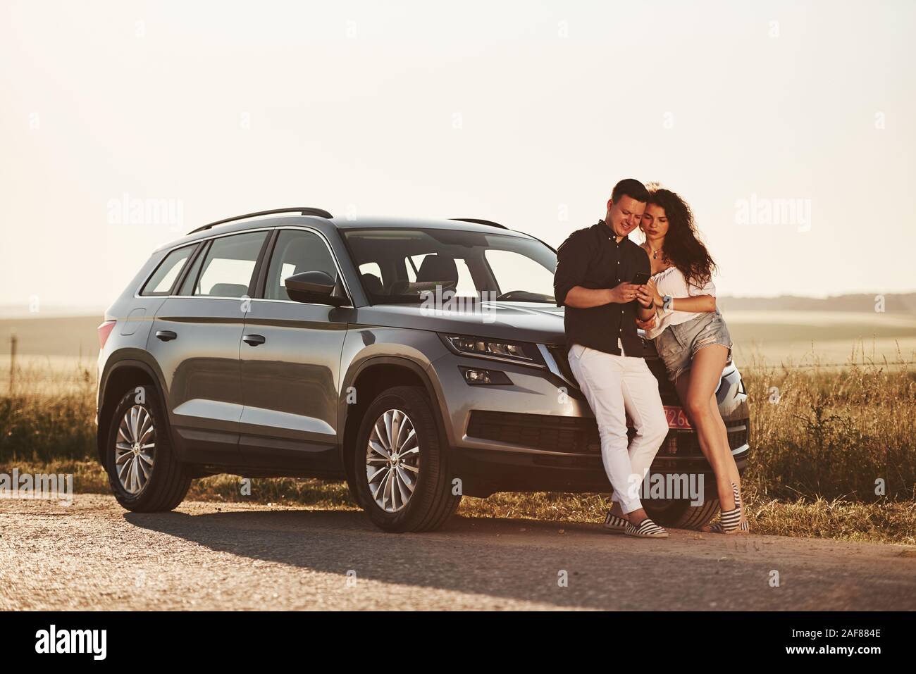 Happy owners of automobile. Lovely couple near their new modern car at ...