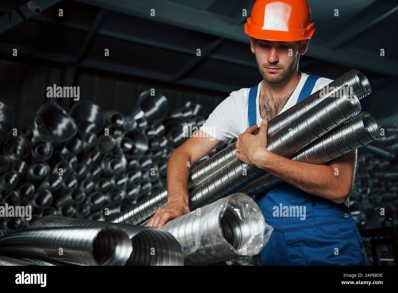 Final product. Man in uniform works on the production. Industrial ...