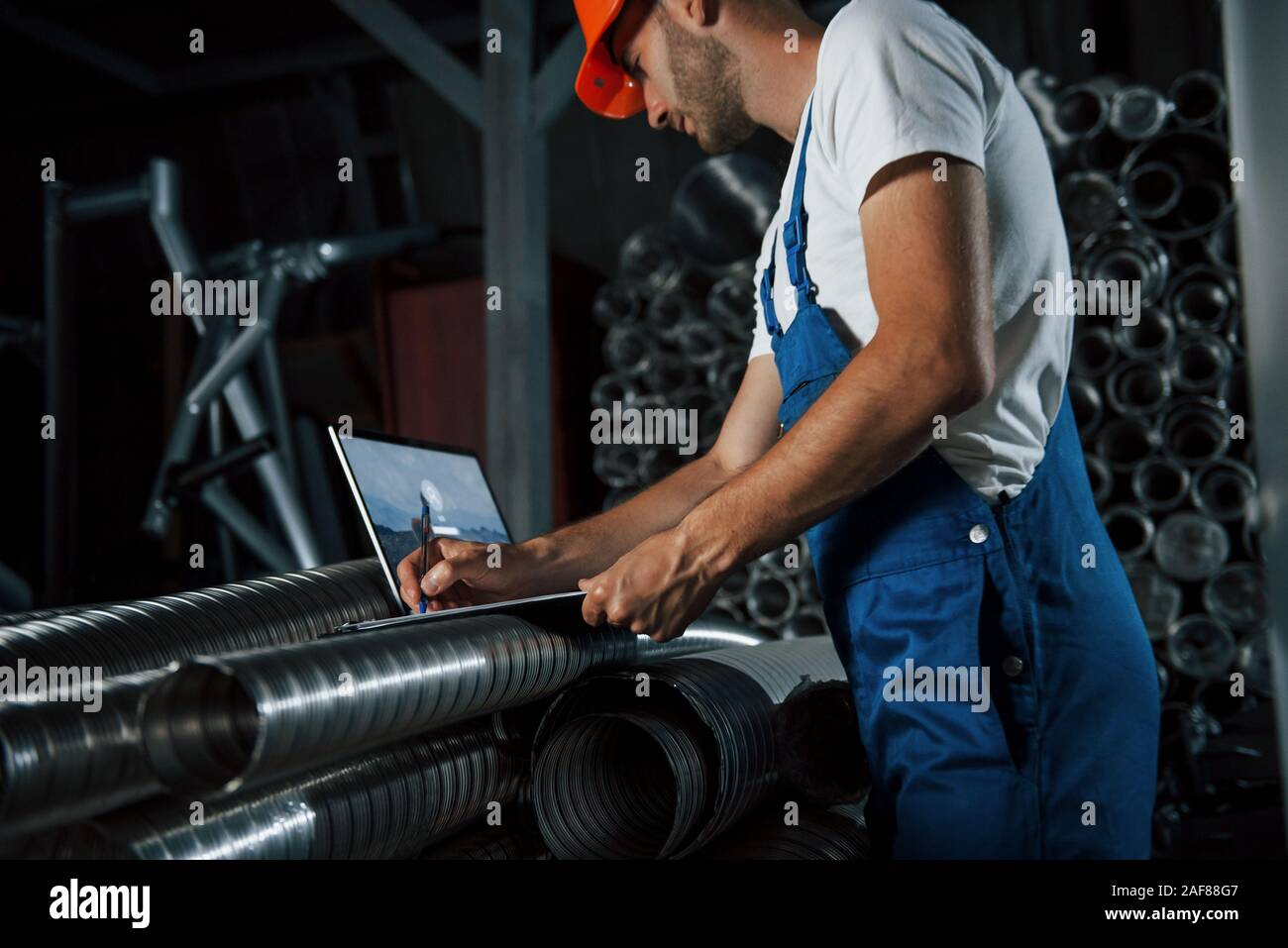 Side view. Man in uniform works on the production. Industrial modern ...