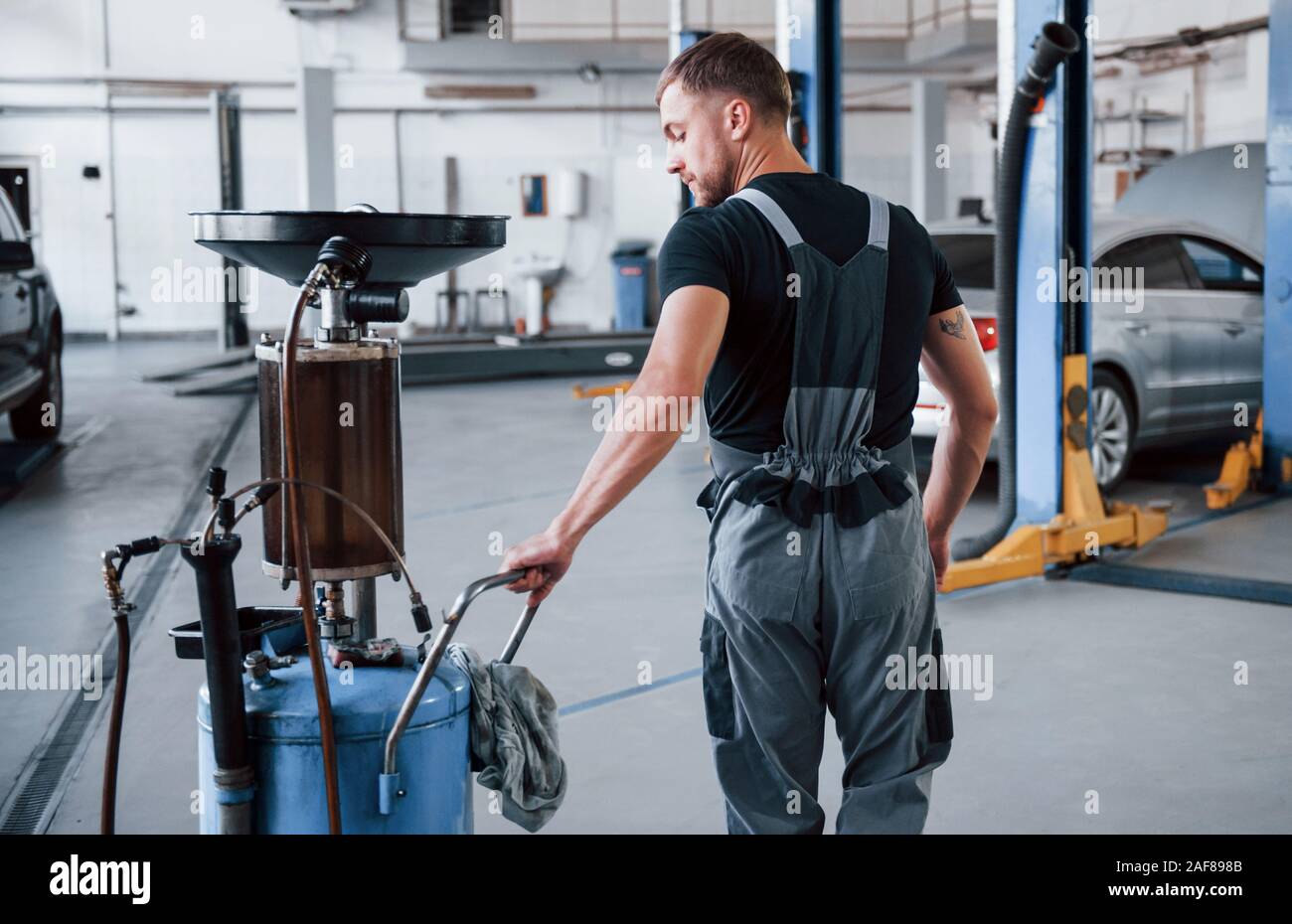 Manual work. Male mechanic use special device to repair broken ...