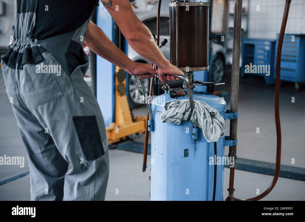 Technology for car restore. Male mechanic use special device to repair ...
