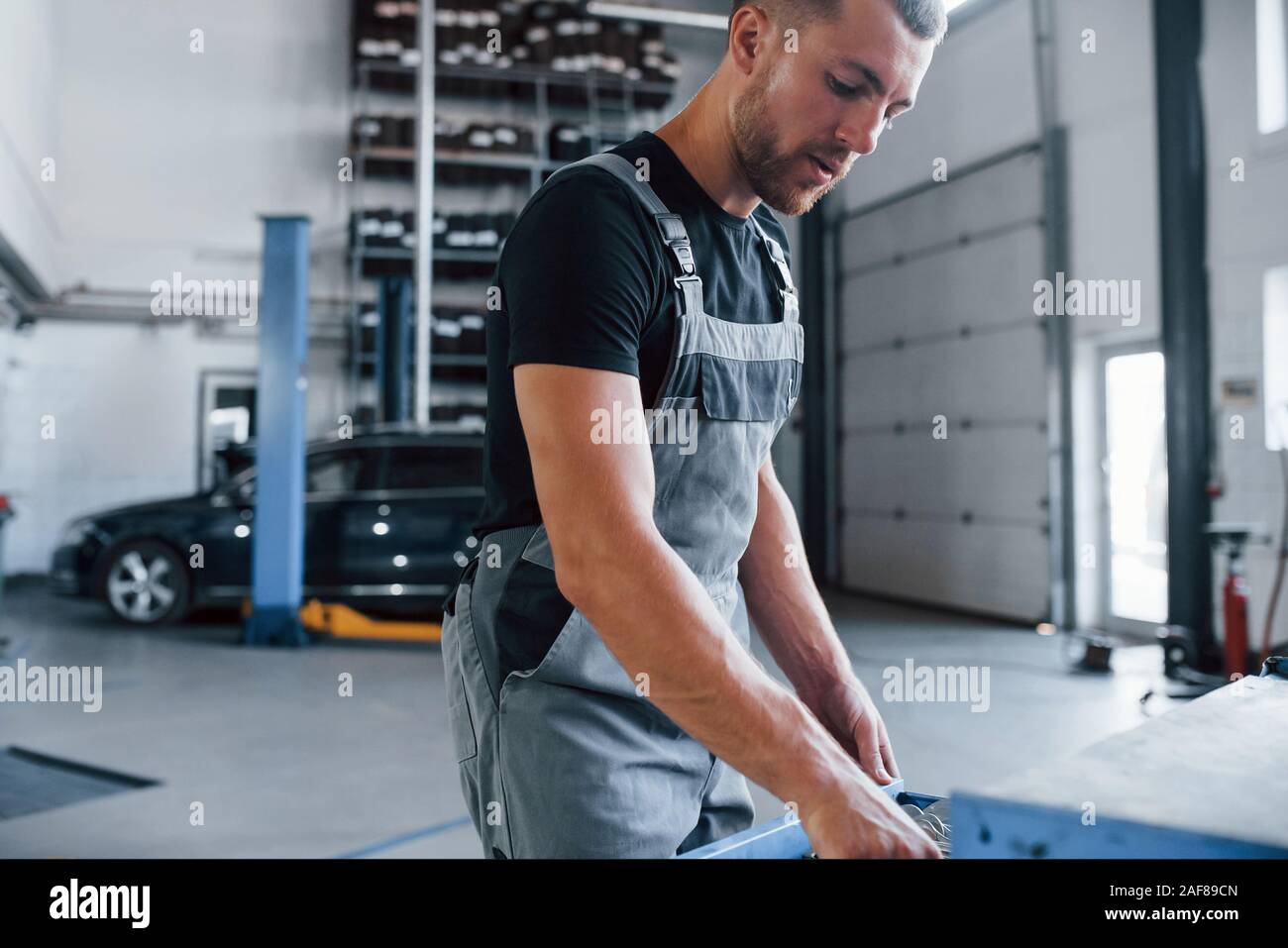 Searching for right instruments. Male mechanic use different tools to ...