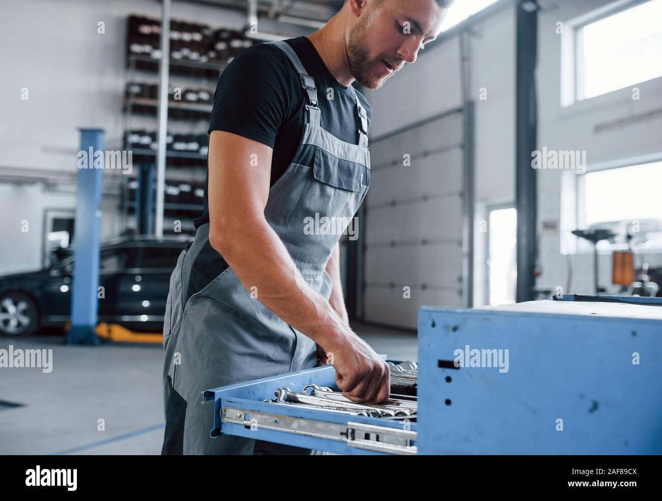 Different sizes. Male mechanic use different tools to repair broken ...