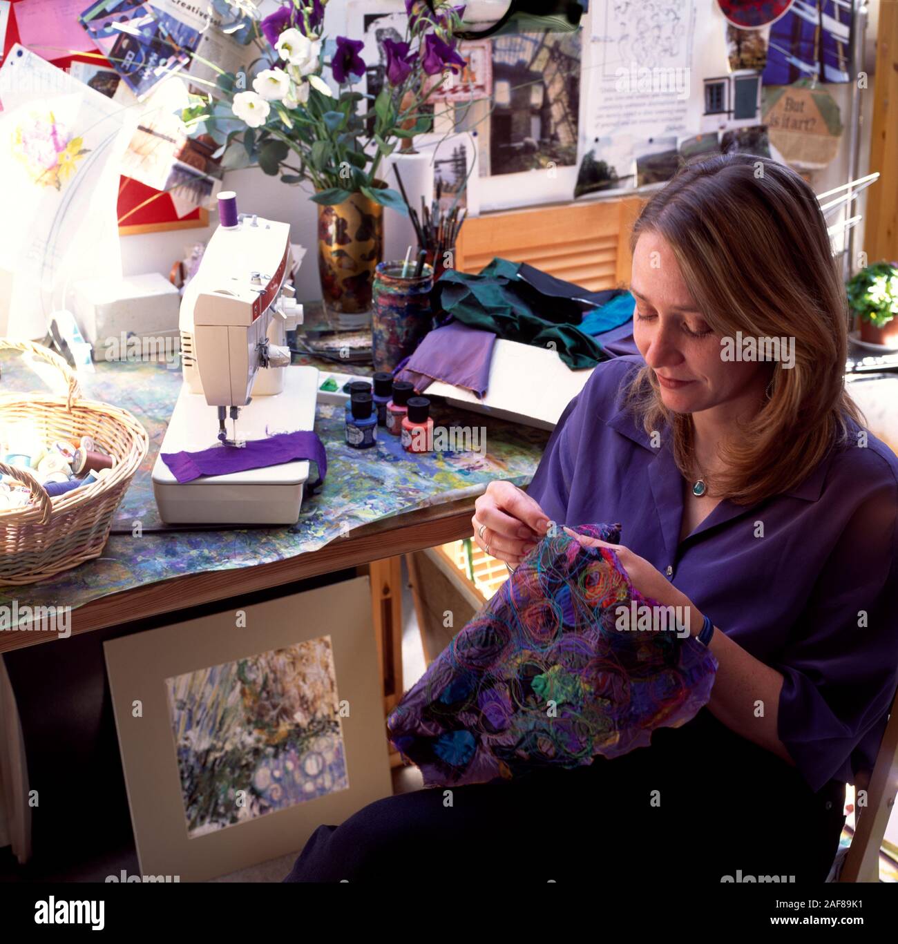 Woman sewing in front of machine Stock Photo - Alamy