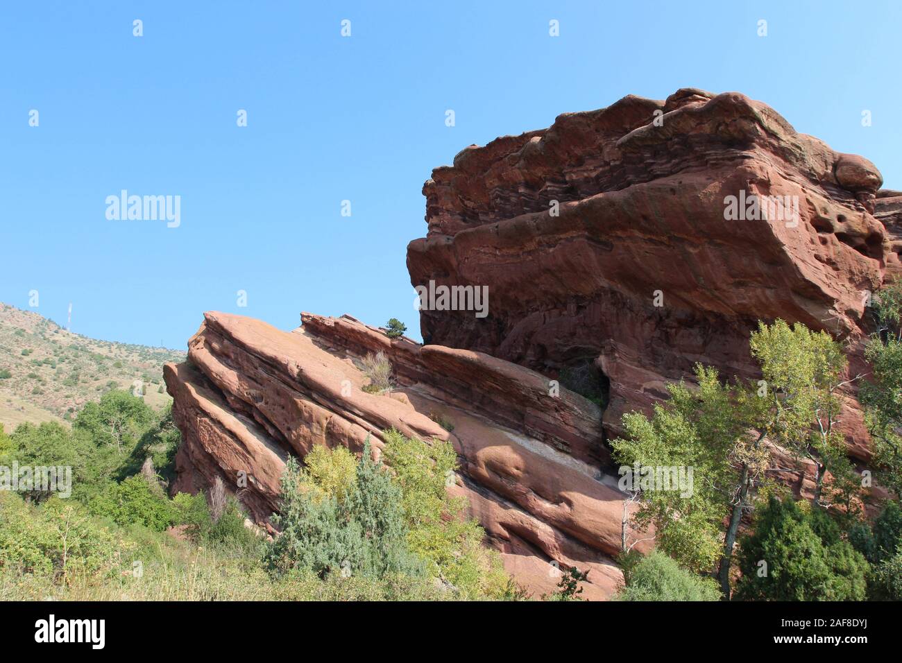 Dramatic red sandstone formation jutting out of the ground, surrounded ...