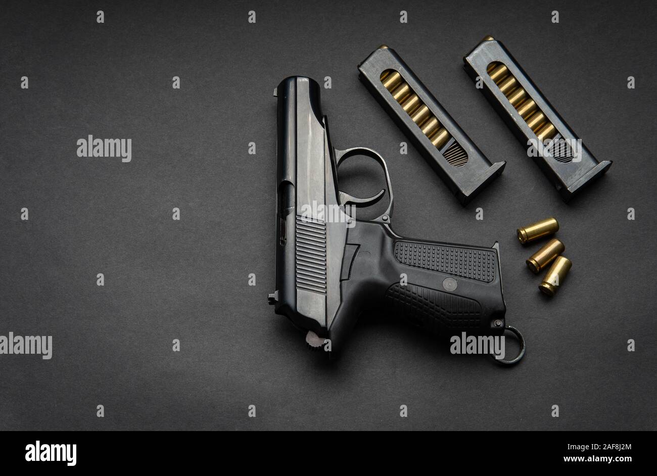 A modern black pistol and ammunition on dark background. Weapons for ...