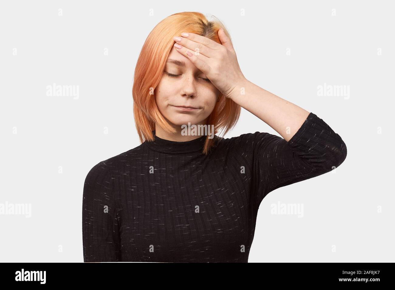 Young woman puts hand to face in shame. facepalm Stock Photo - Alamy