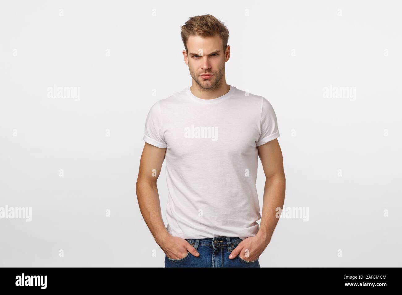 Angry, judgemental handsome macho blond male model in white t-shirt ...