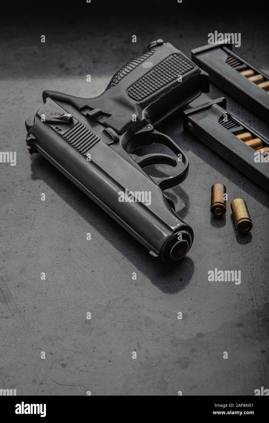 A modern black pistol and ammunition on dark metal background. Weapons ...