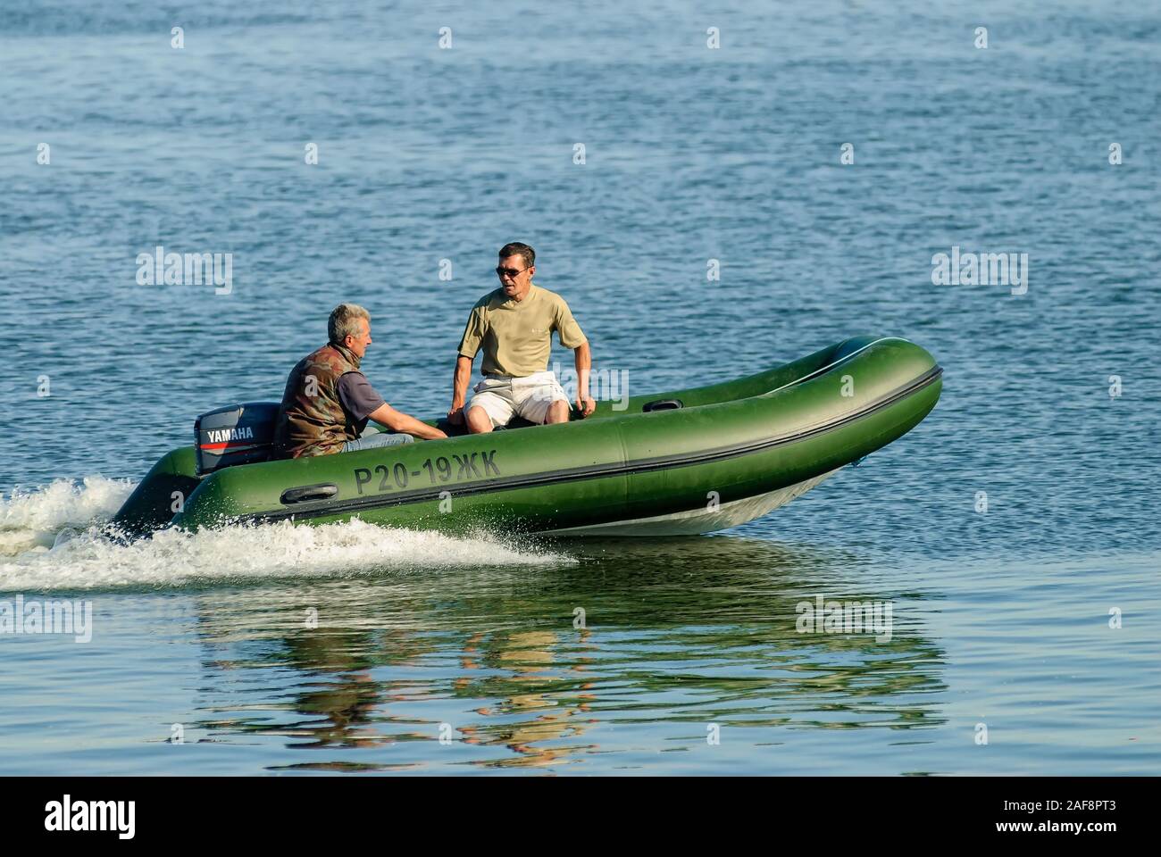 People in rubber boat with motor float Stock Photo - Alamy