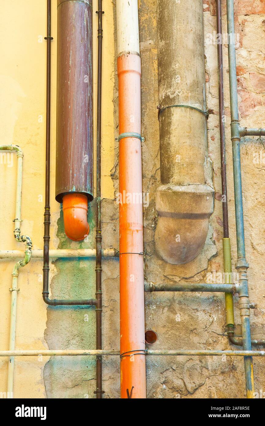 Old hydraulic system with an orange polypropylene exhaust pipes and ...