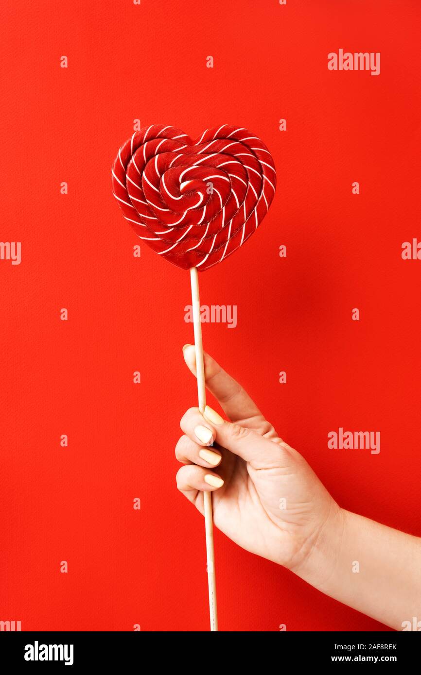 Female hand holding a large blue and white striped lollipop Stock Photo ...