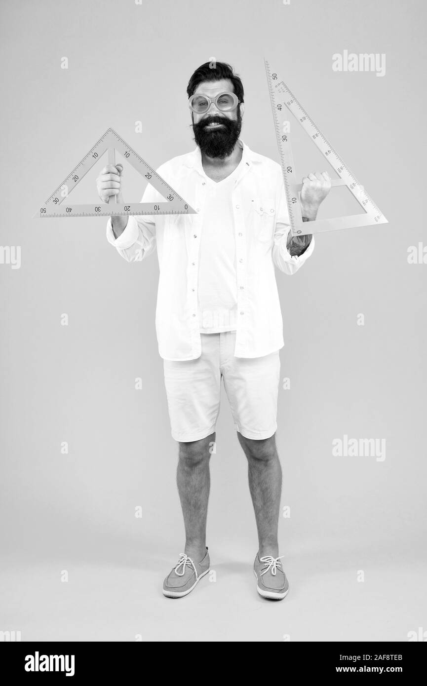 Learning triangles is easy here. Happy bearded man holding triangles on ...