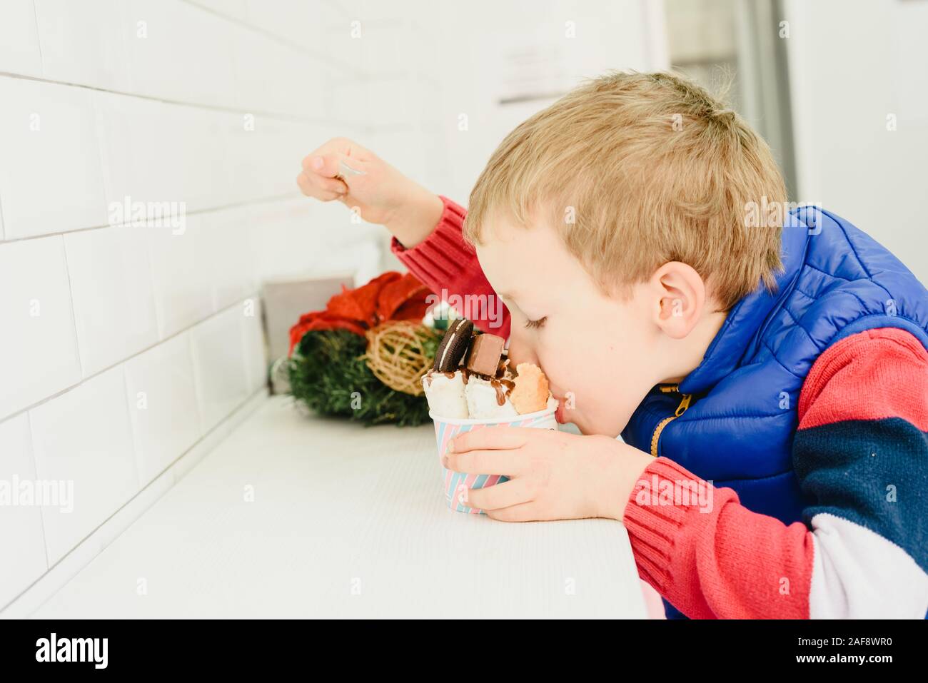 Child tasting an ice cream and eating it with childish cravings Stock ...