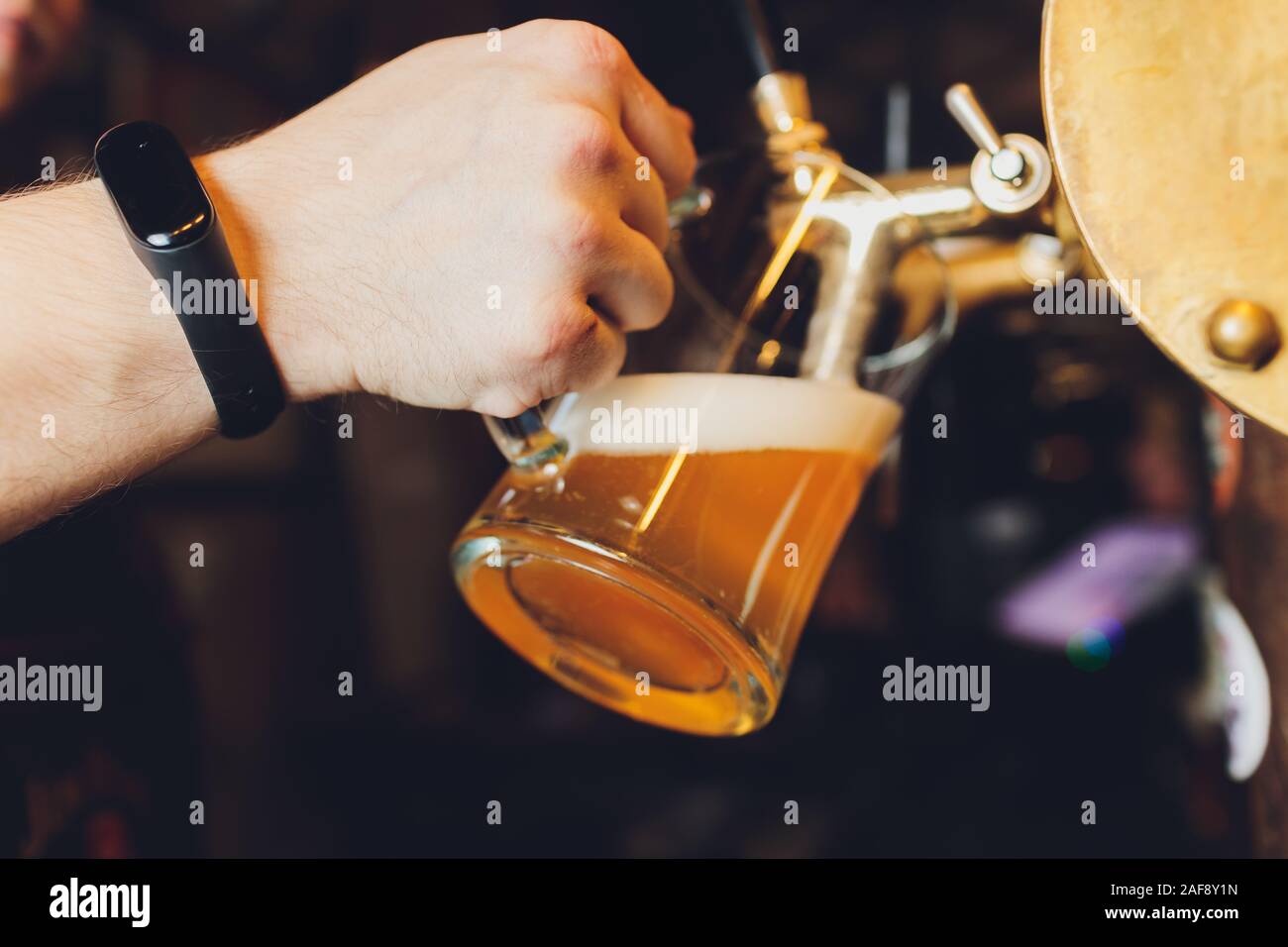 close-up of barman hand at beer tap pouring a draught lager beer Stock ...